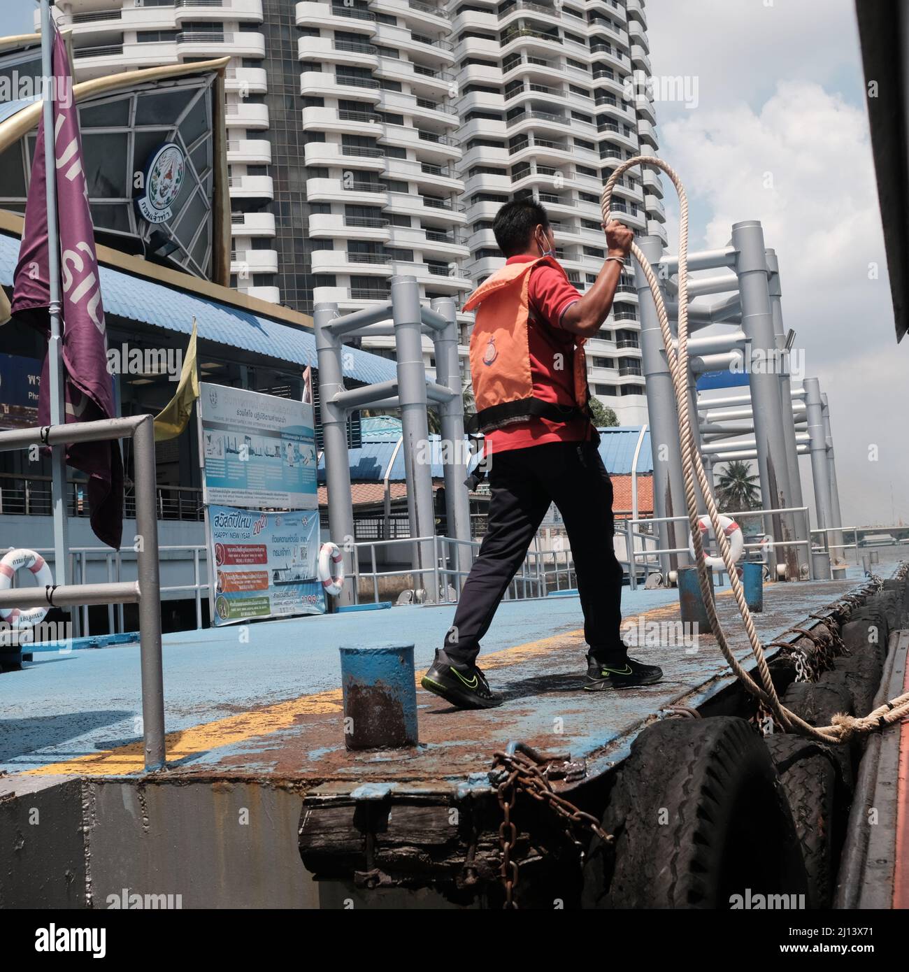 Worker on Orange Flag Express Boat Seaman Boatswain man on the ropes ...