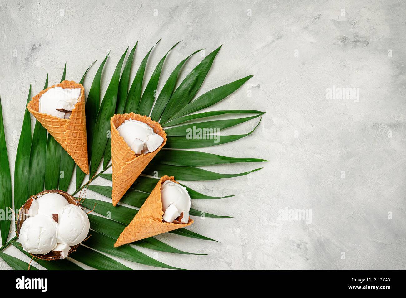 Coconut ice cream cones on palm leaf with copy space. Summer background ...
