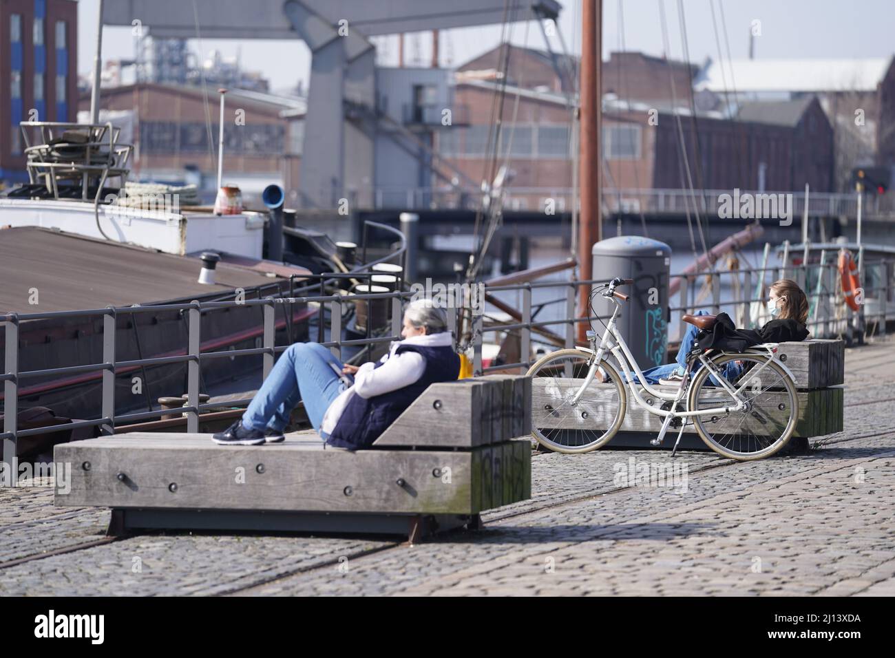22 March 2022, Hamburg: People enjoying the sun in Harburg harbor ...