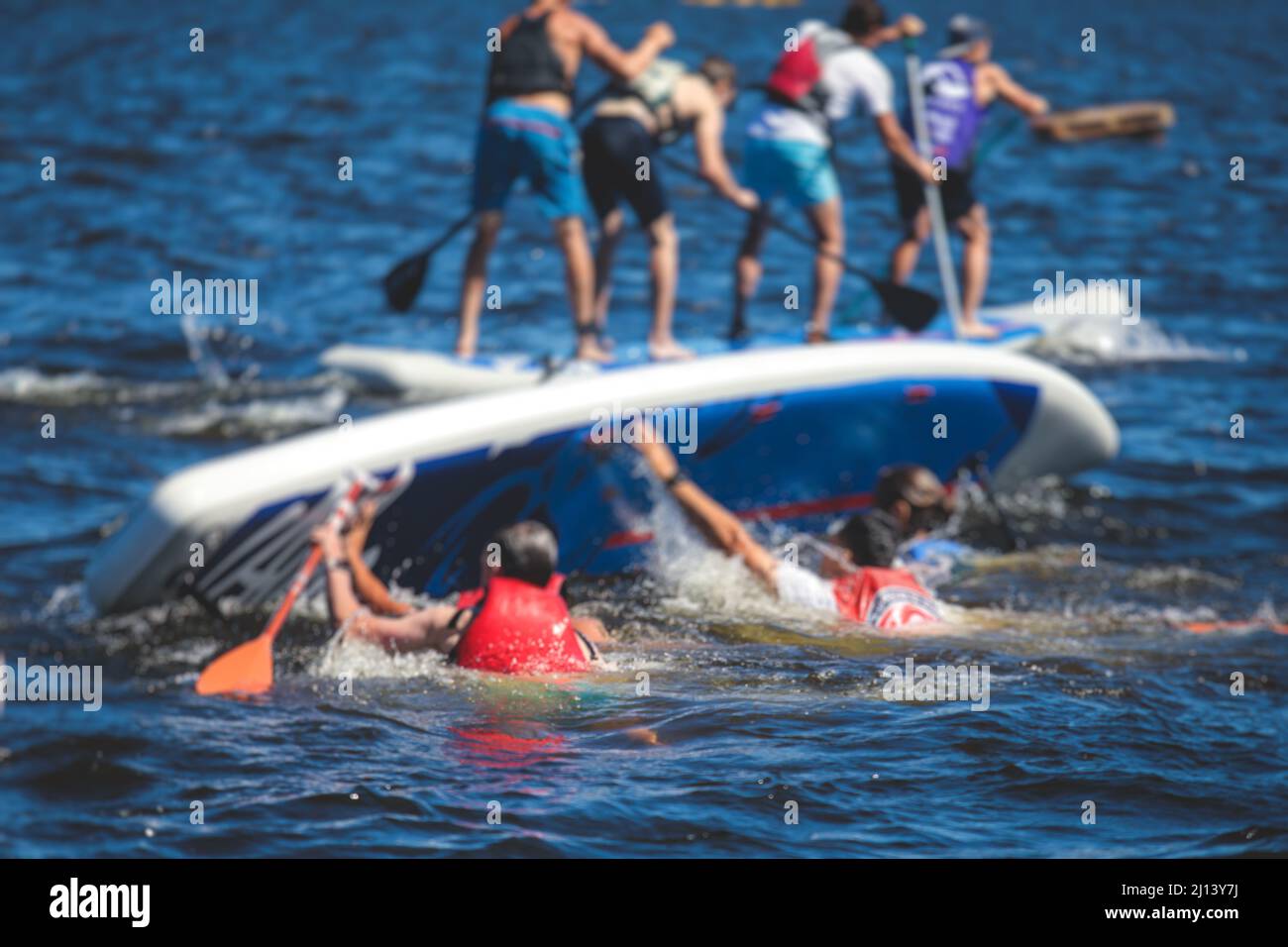 Group of young SUP surfers fall from stand up paddle board, women ...