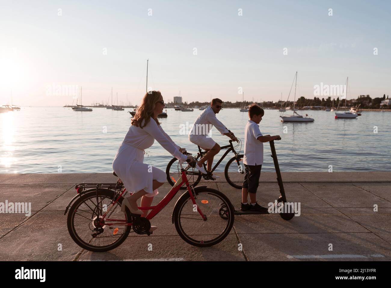 Happy family enjoying a beautiful morning by the sea together, parents ...