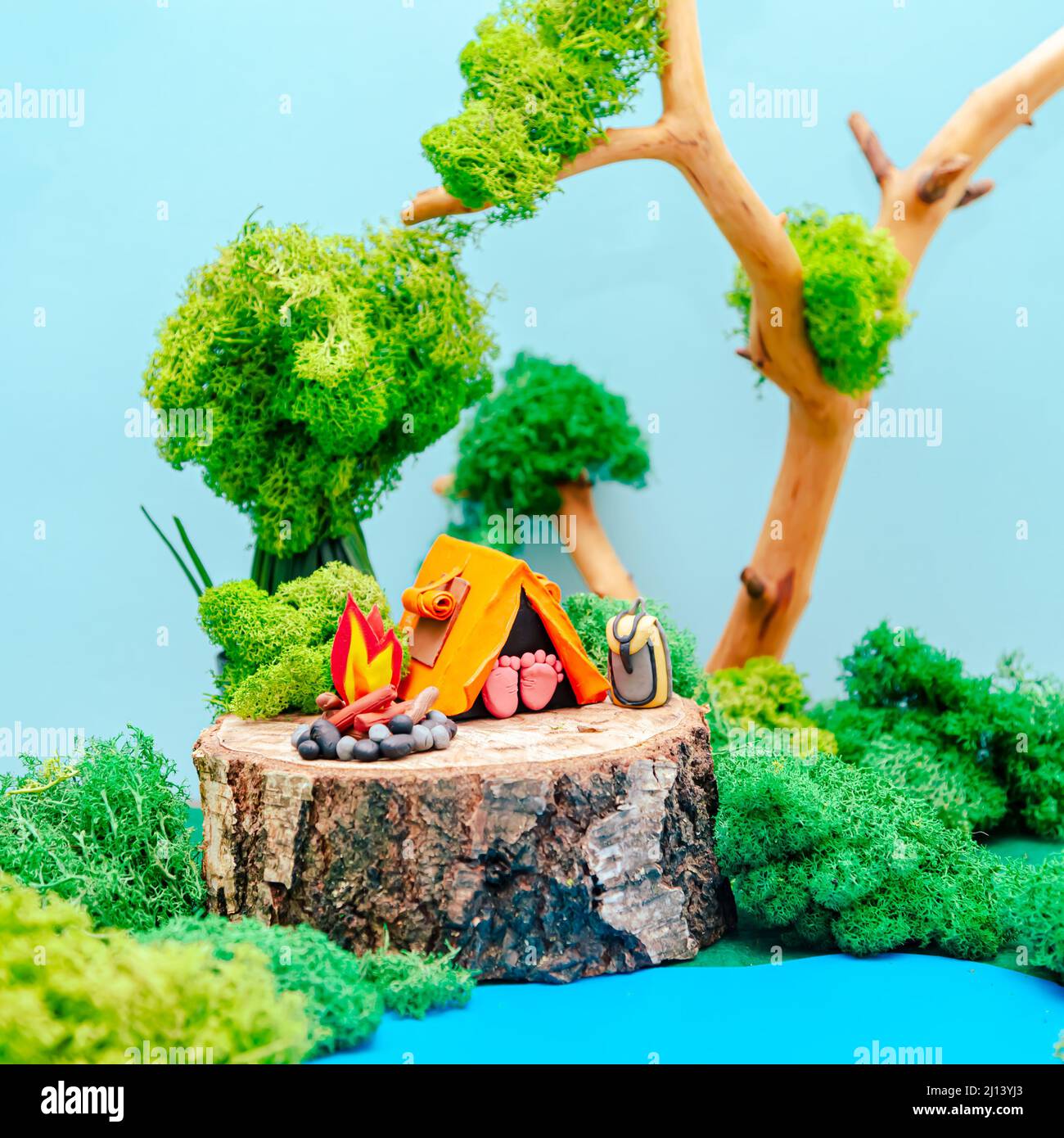 Tourist camp. Plasticine landscape with a tent, a campfire and a ...