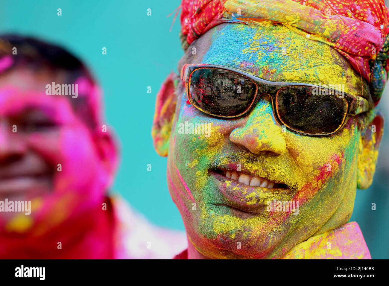 A reveler with a colorful painted face during a procession on Rang ...