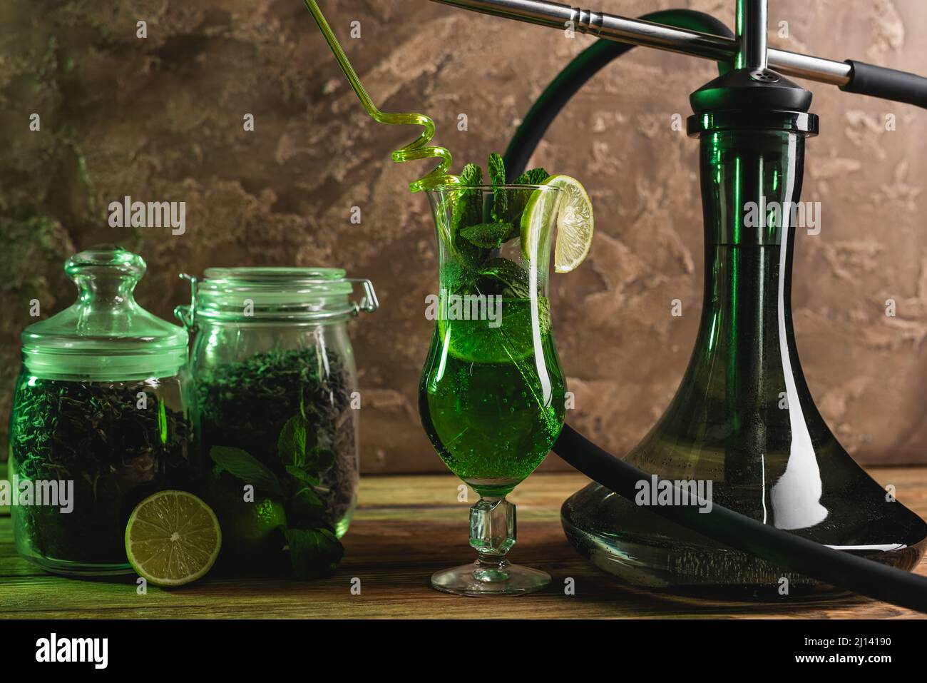 Cocktail, dry tea and hookah on wooden surface on textured stone ...