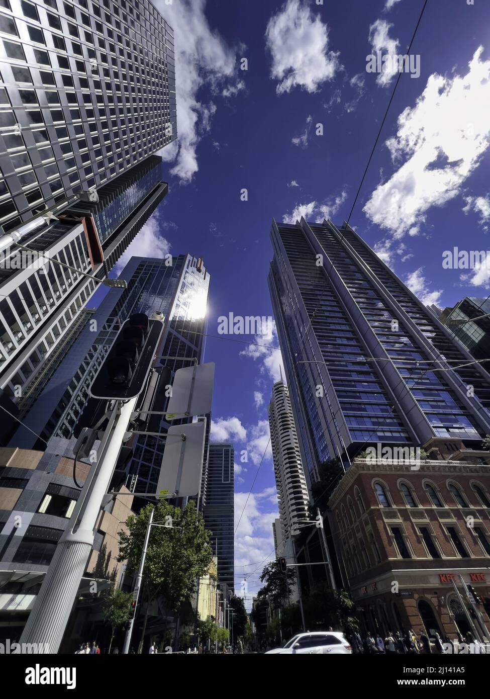 Low angle of the modern skyscrapers gleaming under the cloudy blue sky ...