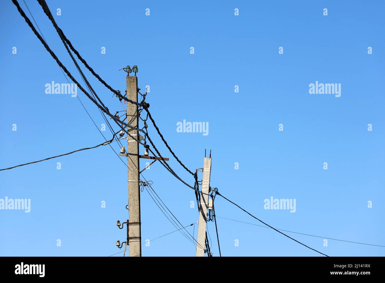 Power line posts with tangled electrical wires and capacitors on blue ...