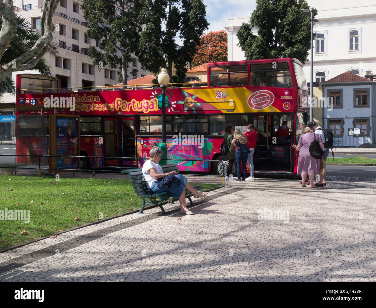 Customers buying tickets to go on Big Red open-top sightseeing tour bus ...