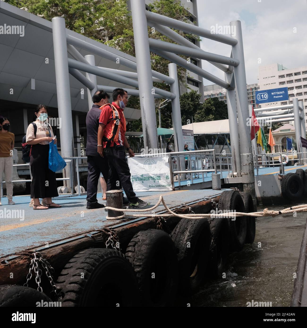 Worker on Orange Flag Express Boat Seaman Boatswain man on the ropes ...