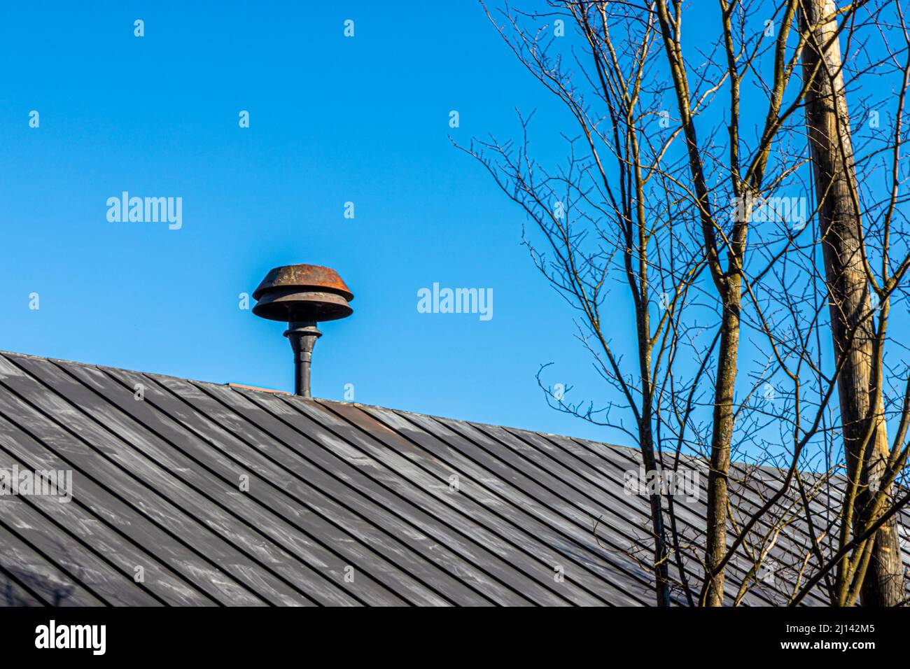 Rusty vintage mechanical civil defence siren on the roof of a building ...