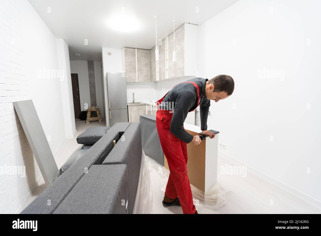 Man repairing a sofa, worker assembles sofa Stock Photo - Alamy