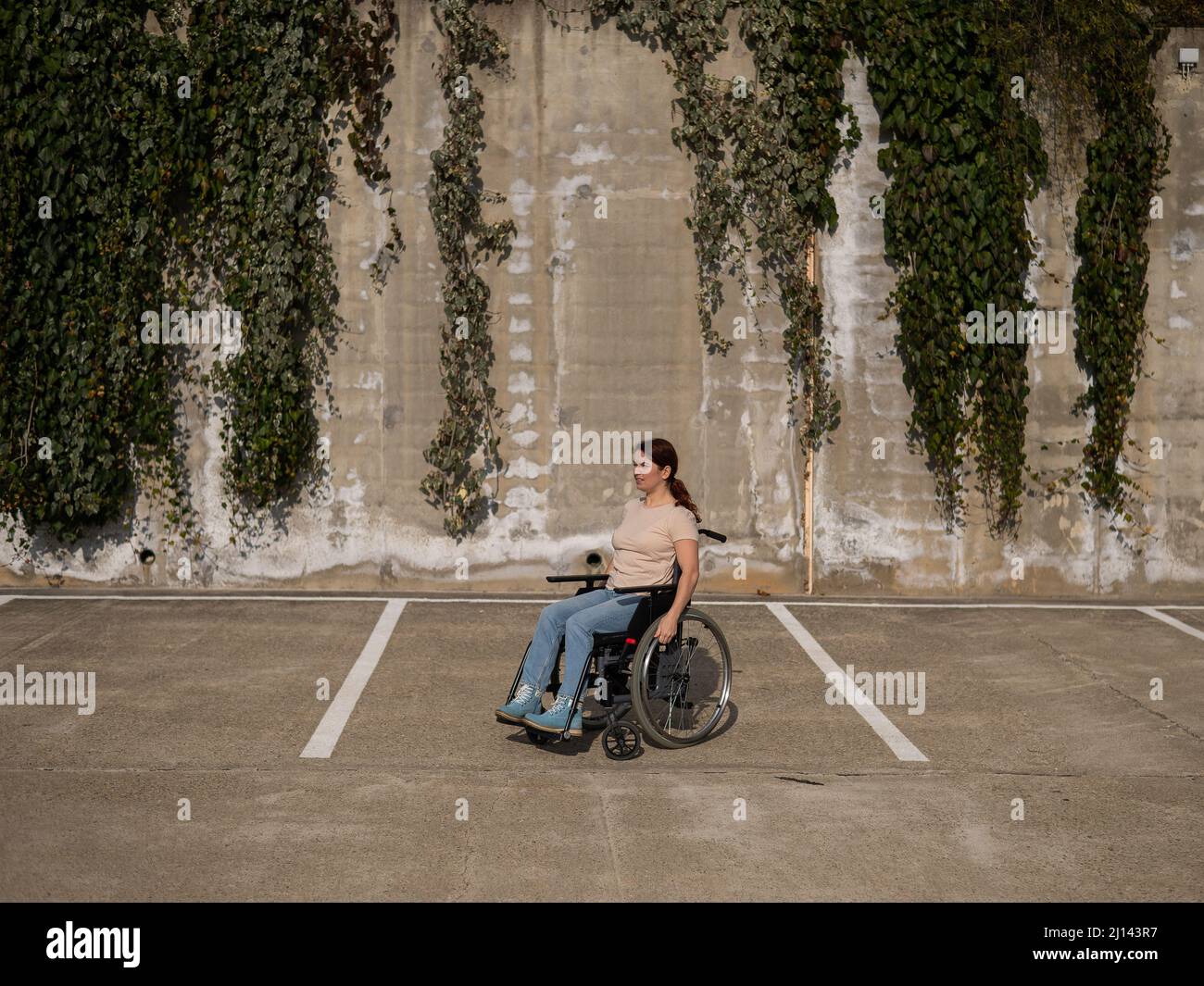 Woman riding a wheelchair in a parking lot Stock Photo - Alamy