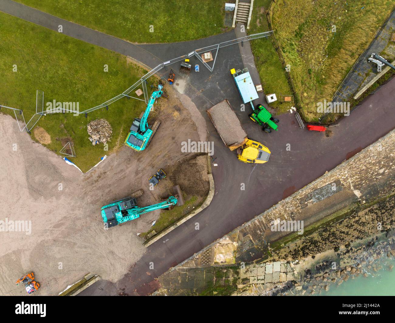 Aerial view of An excavator and a dumper working on coastal defences at ...