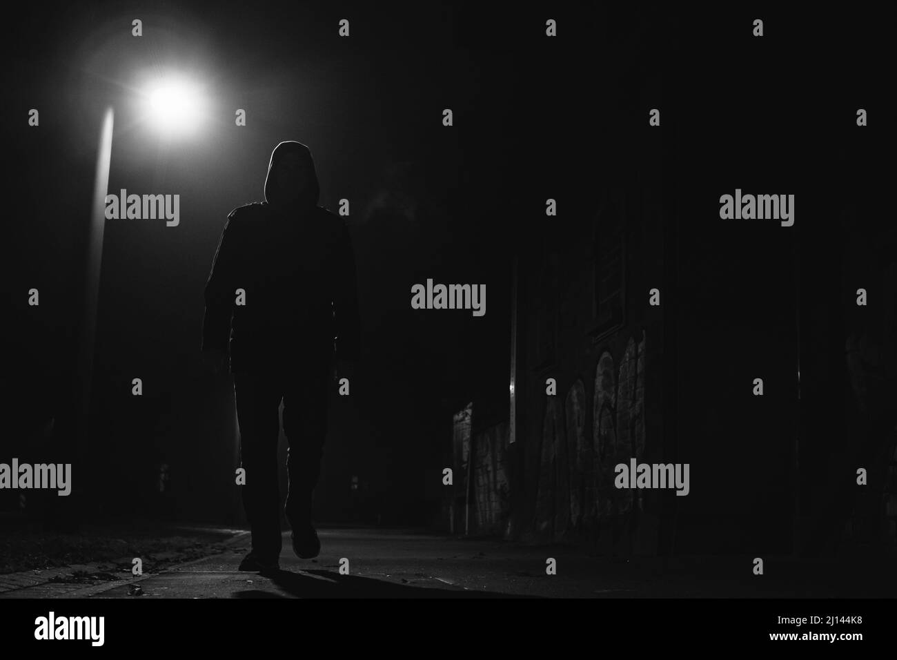 Lonely man walking outside at night Stock Photo - Alamy