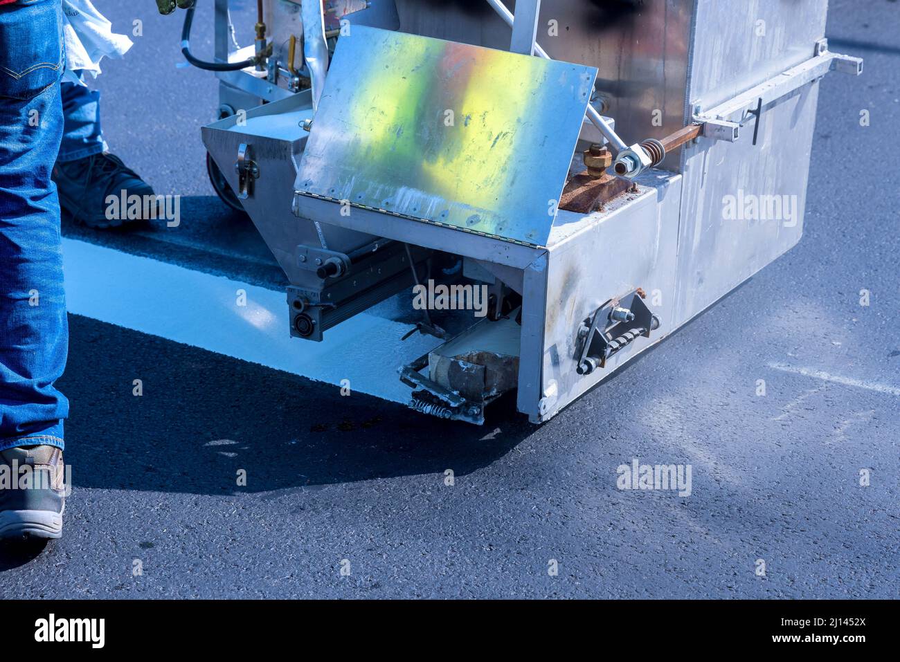 Worker thermoplastic spray marking machine painting work on the street ...