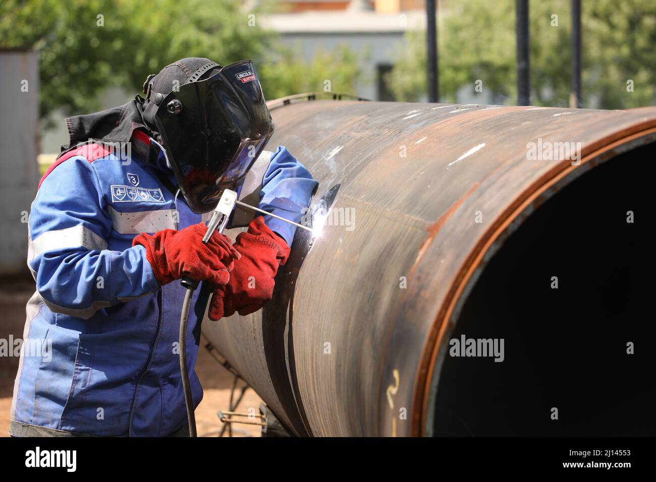 Male welder works. Welding joint of large diameter pipe. High pressure ...
