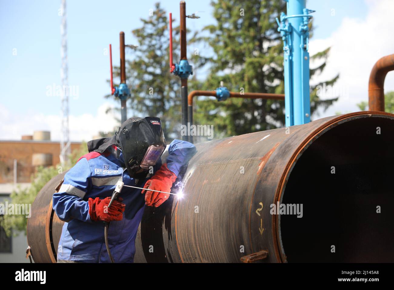 Male welder works. Welding joint of large diameter pipe. High pressure ...