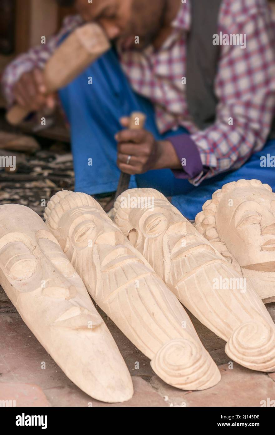 carpenter, man carving wood with hammer and wood carving chisel behind ...