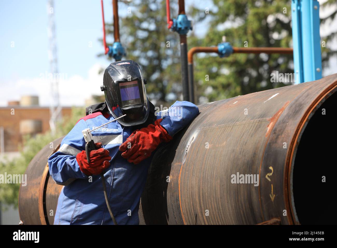 Male welder works. Welding joint of large diameter pipe. High pressure ...