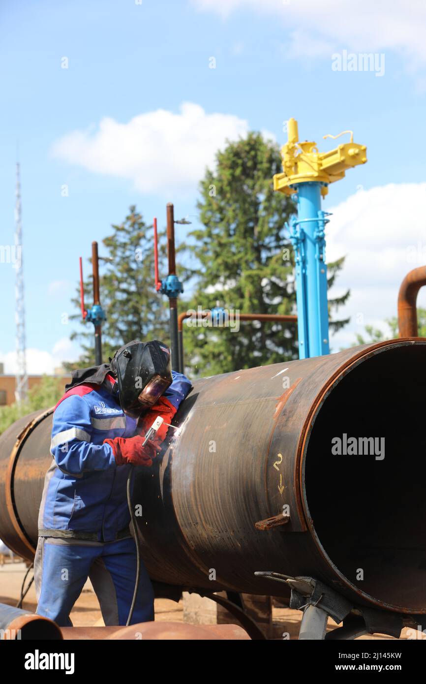 Male welder works. Welding joint of large diameter pipe. High pressure ...