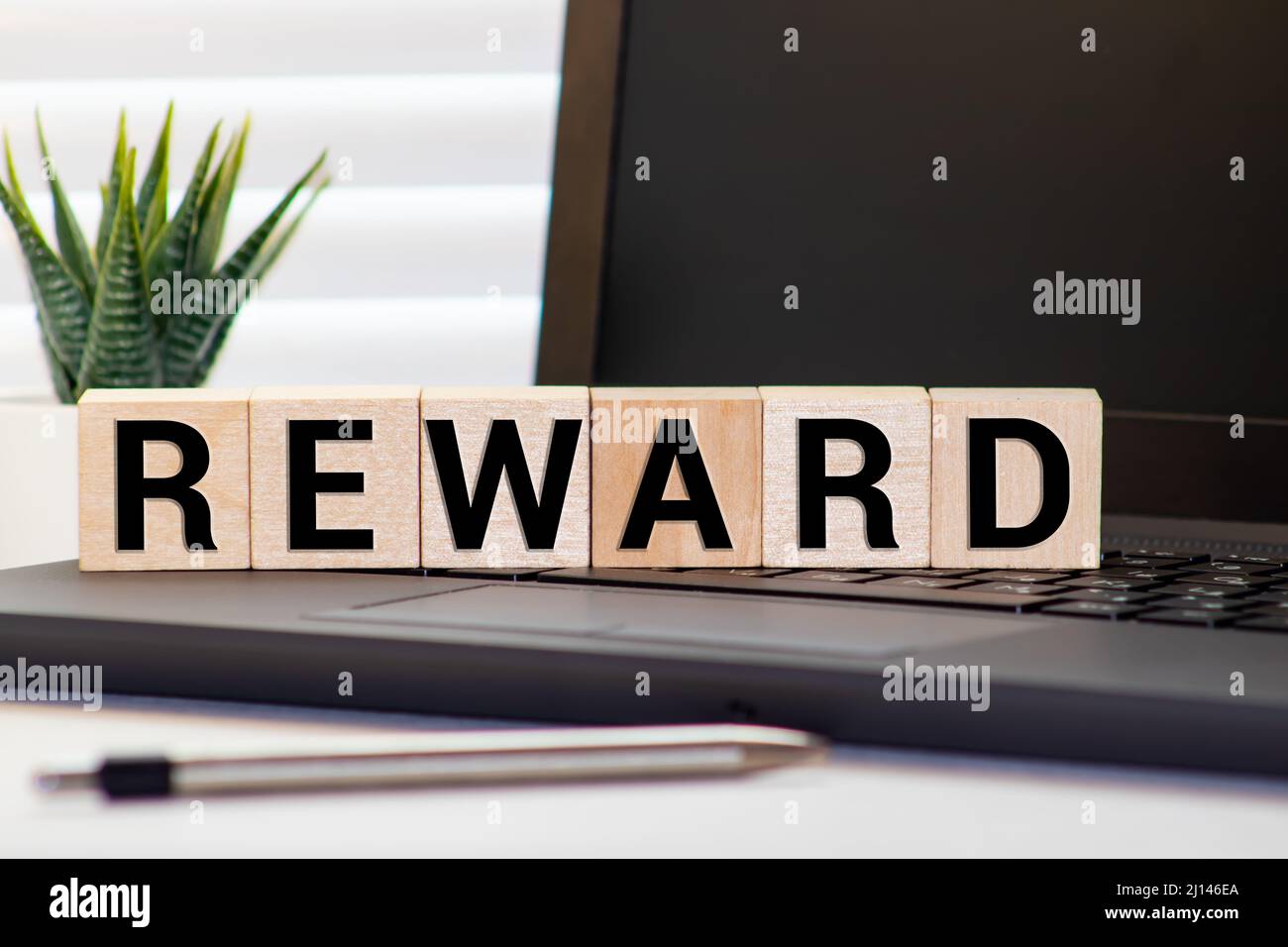 Reward written on a wooden cube in office desk Stock Photo - Alamy