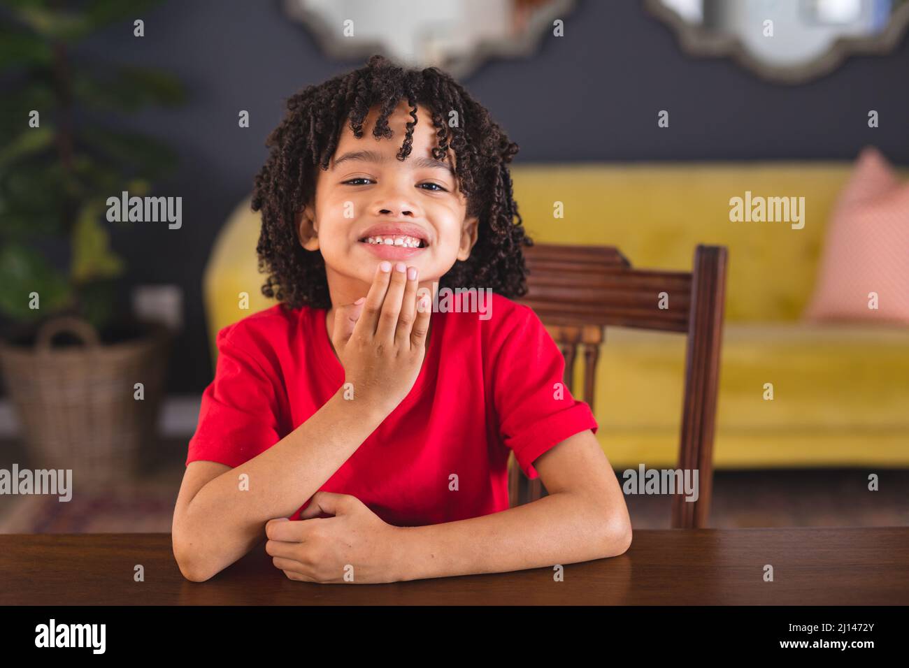 Portrait of smiling hispanic boy talking through hand sign language at ...