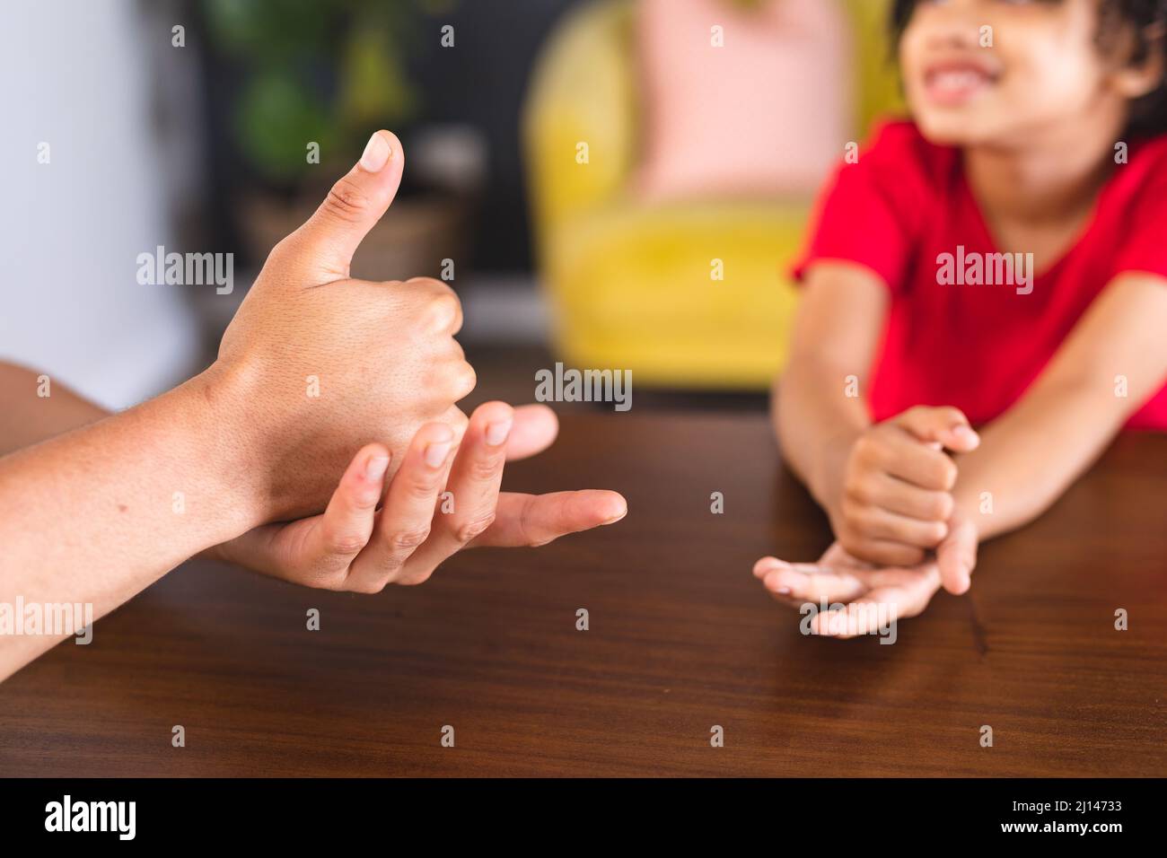 Hispanic father and son talking through hand sign language while ...