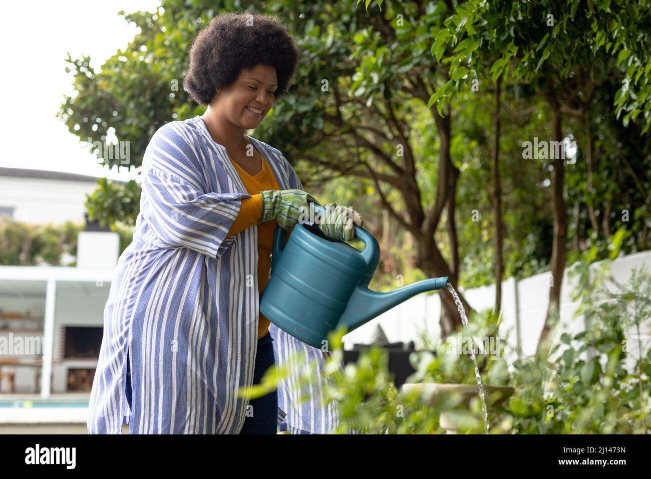 African woman watering can hi-res stock photography and images - Alamy