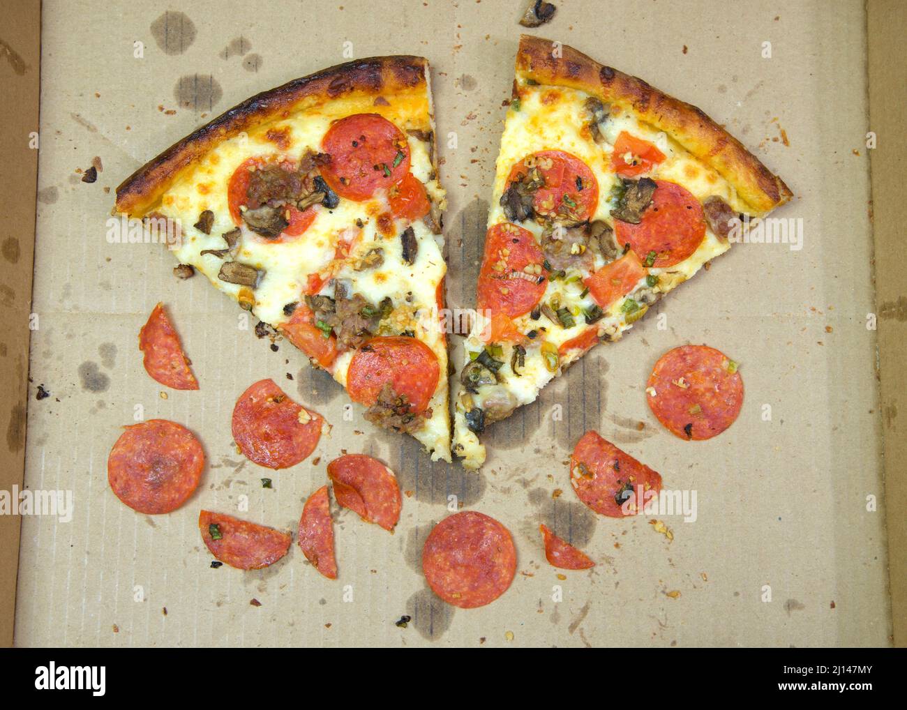 Above top view of stray slices of garlic supreme pepperoni pizza in ...