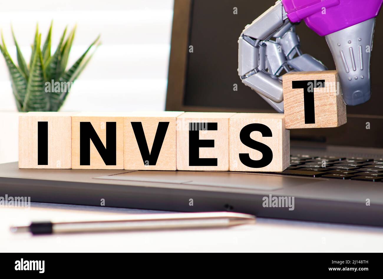 invest word written on wood block, businnes concept Stock Photo - Alamy