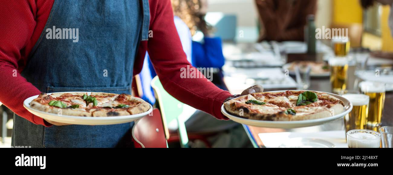 Waiter serving delicious pizza in cozy pizzeria restaurant - Italian ...
