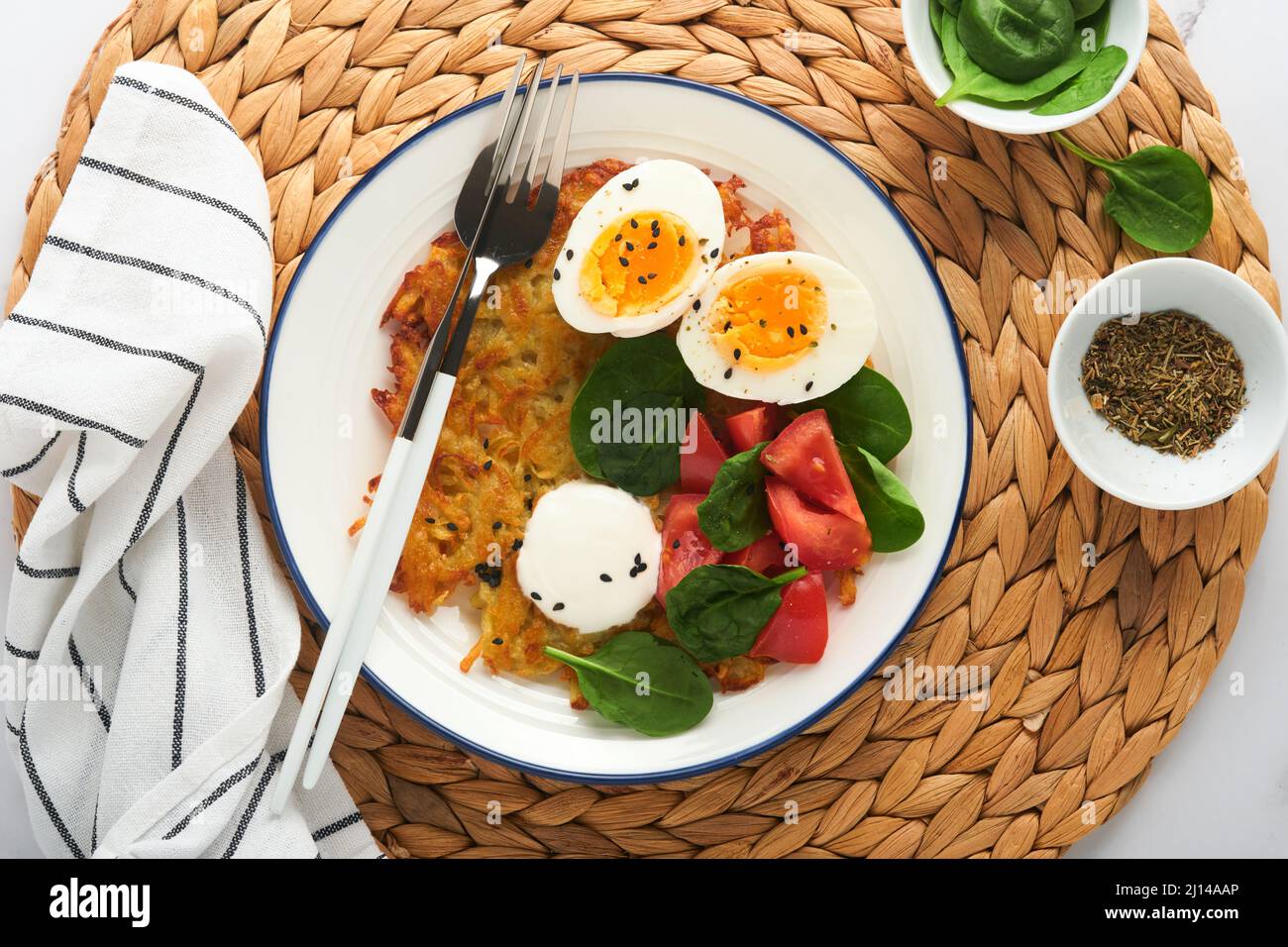 Breakfast. Potatoes latkes with sour cream, spinach salad, tomatoes and ...