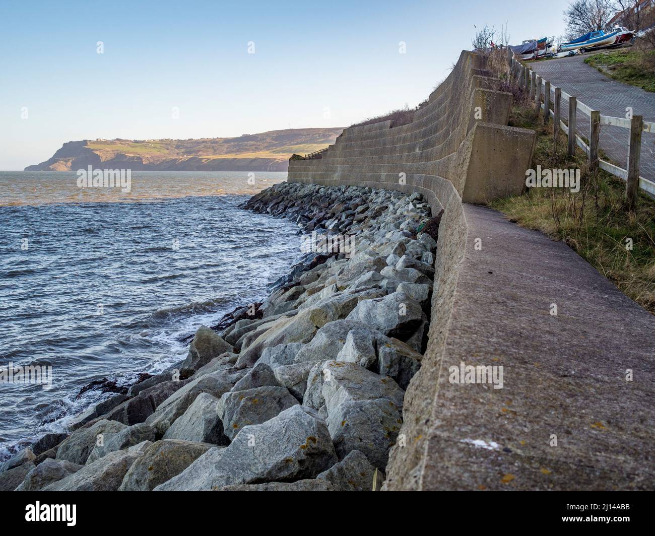 Sea defence at Robin Hood's Bay, with the cliffs of Ravenscar in the ...