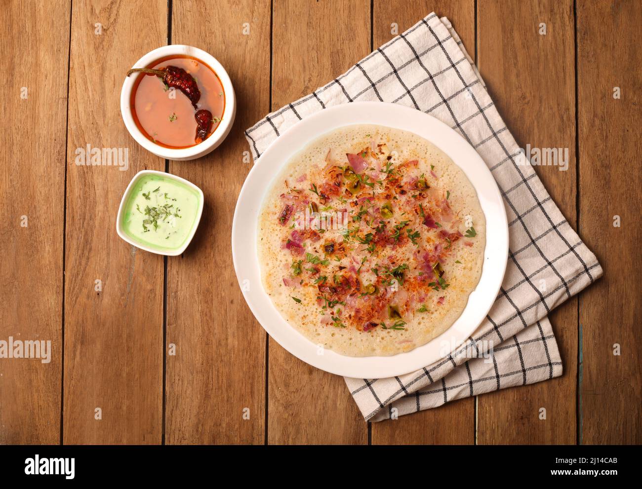 Top view of an Uttapam Dosa Indian dish, Hot sauce and small Salad ...