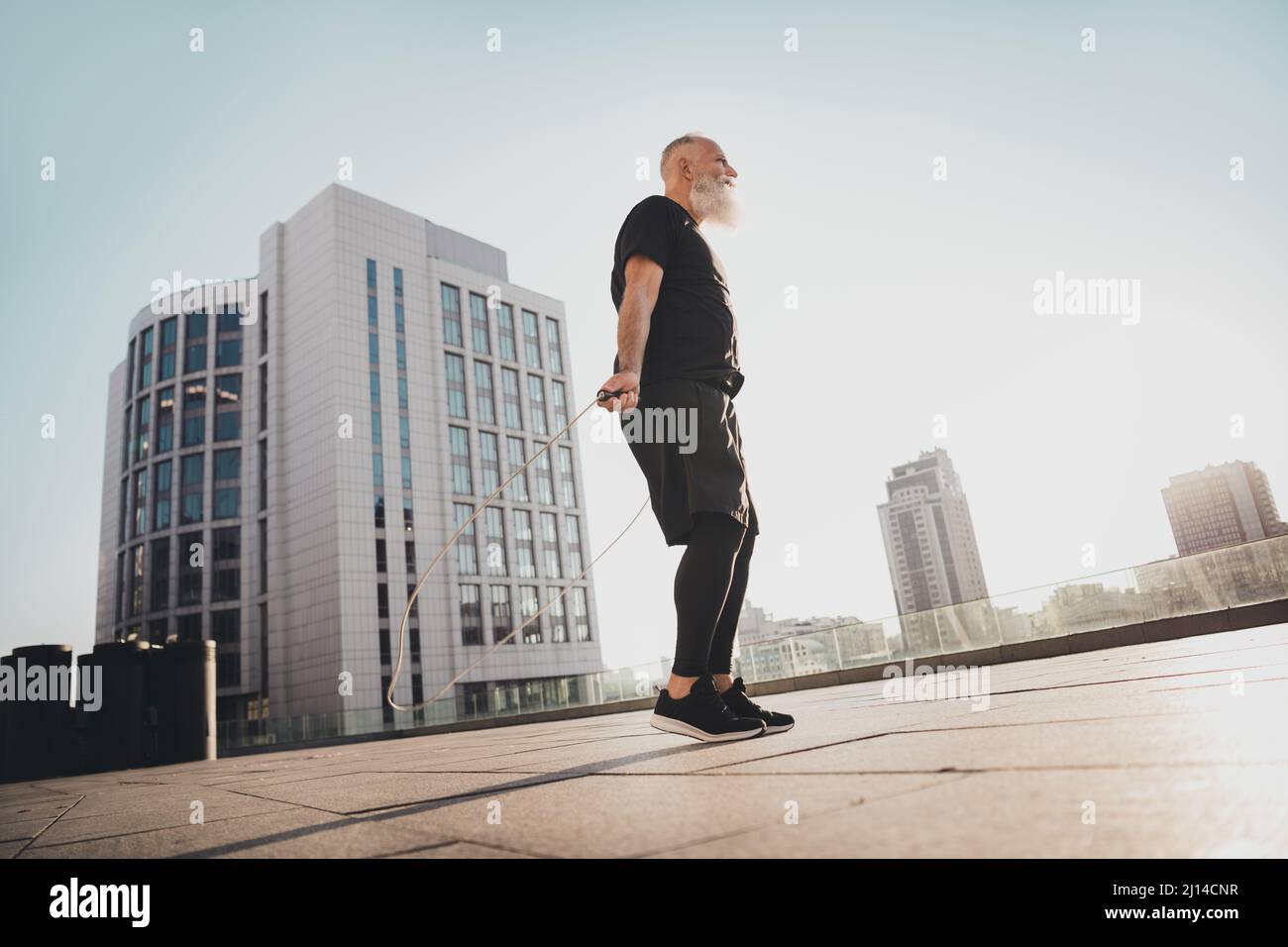 Photo of cardio training concept old man jump skipping rope many times ...