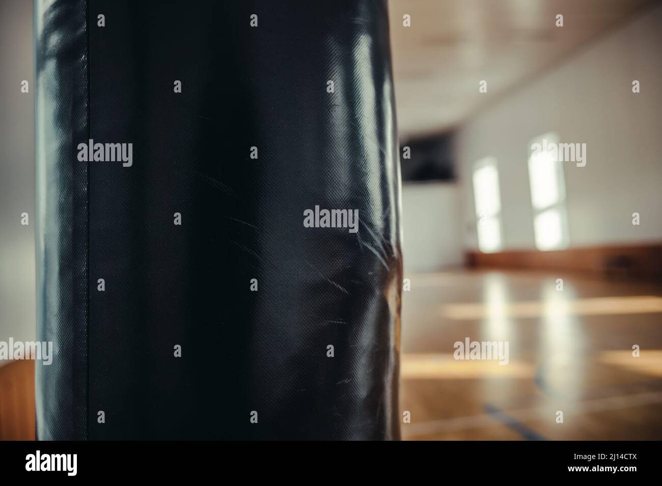 Black boxing bag hangs in empty gym. Close-up with copy space Stock ...