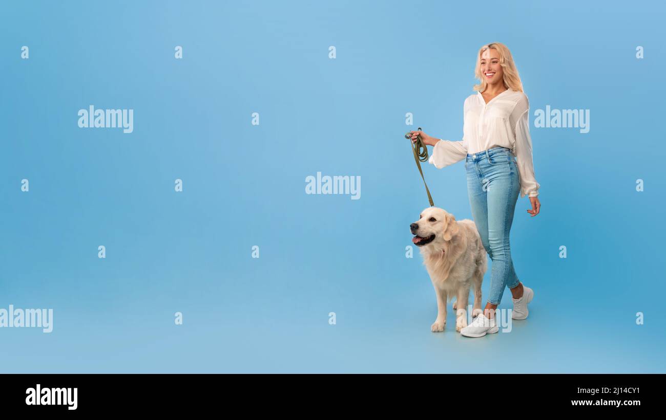 Young woman walking with her dog on a leash Stock Photo - Alamy