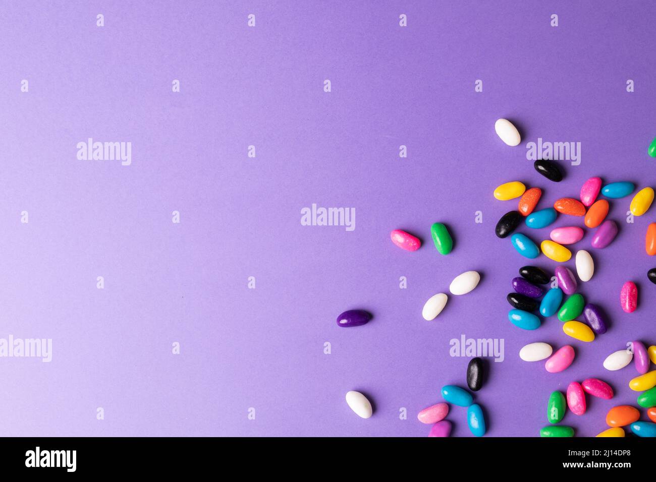 Directly above view of scatted multi colored candies on purple ...