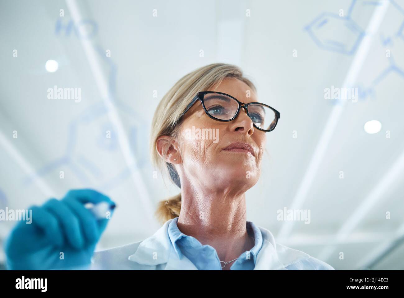 Science is one of the most important channels of knowledge. Shot of a mature scientist drawing ...