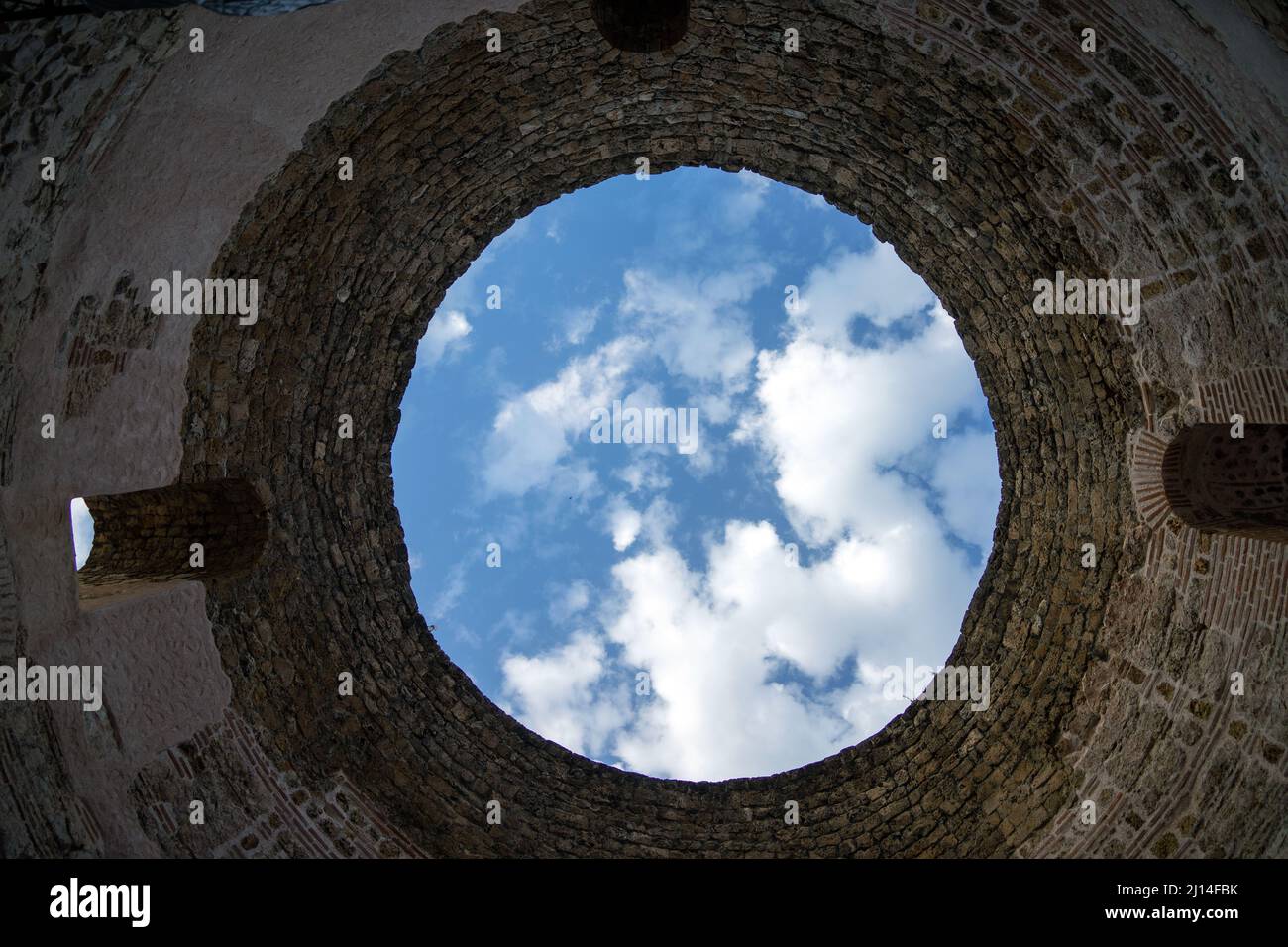 View of the sky from the inside of a tower with a round-shaped hole ...