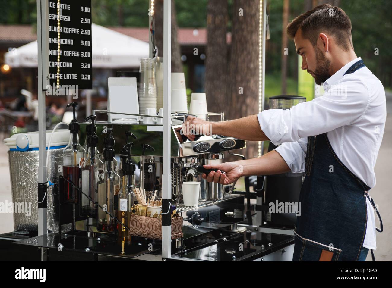 Handsome barista man during work in his street coffee shop Stock Photo ...