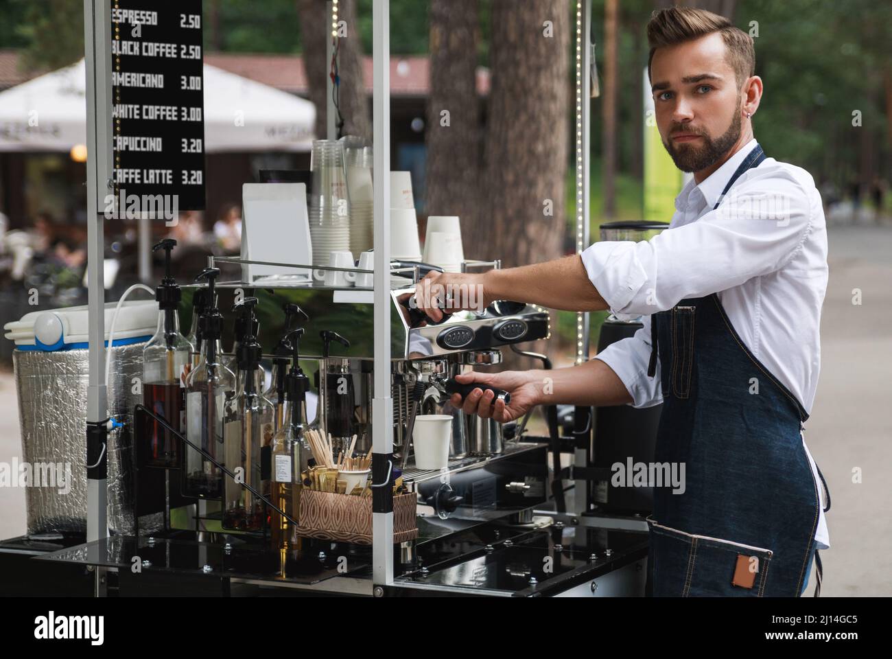 Handsome barista man during work in his street coffee shop Stock Photo ...