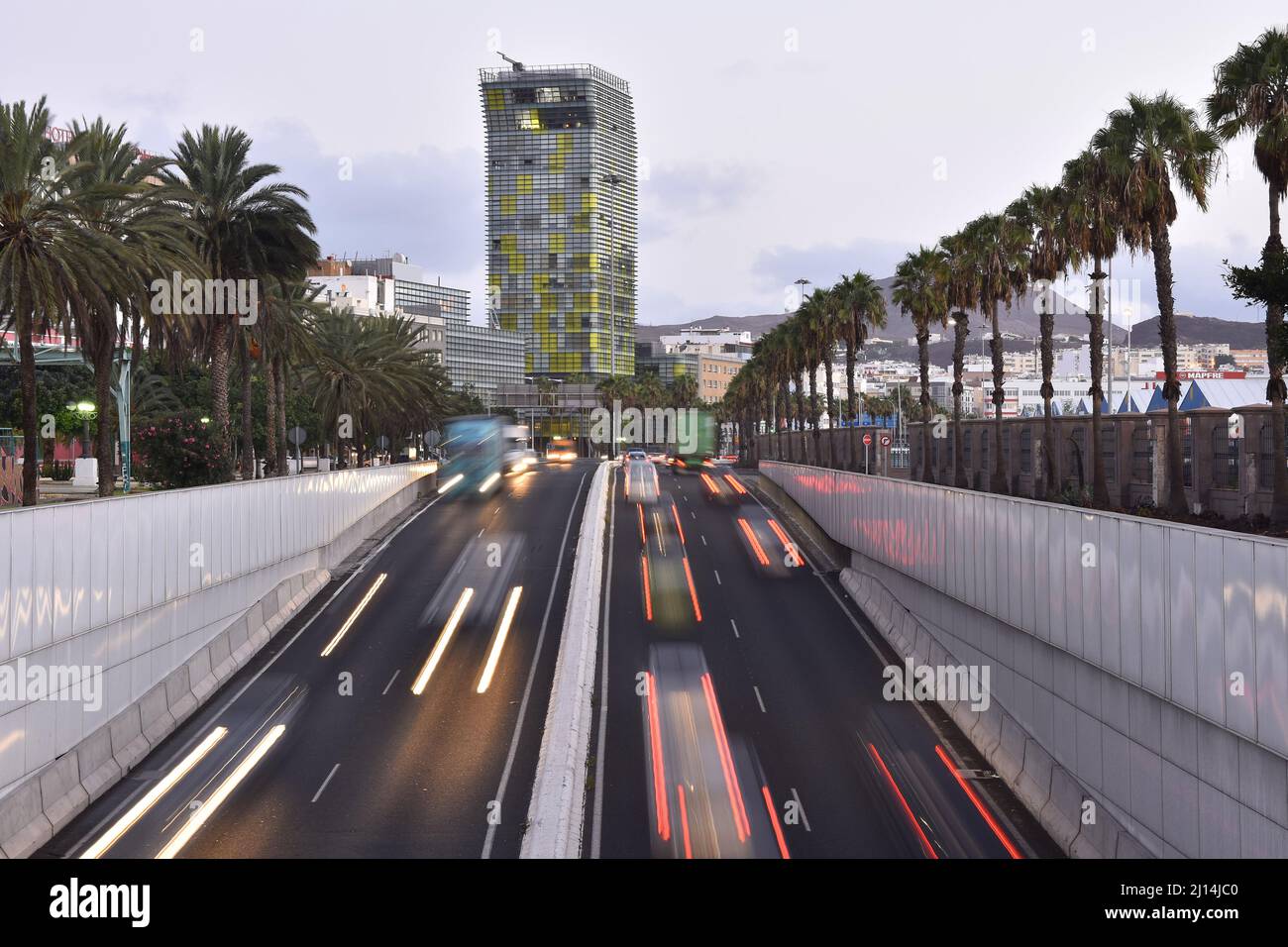 Cars in motion on the driveway at dawn and modern Woermann Tower ...