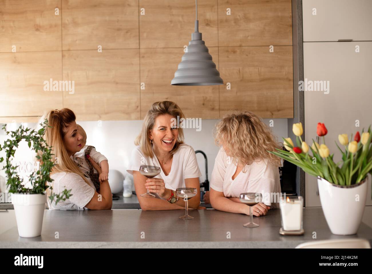 Three women drink cocktails together. Friends drinking on holiday ...