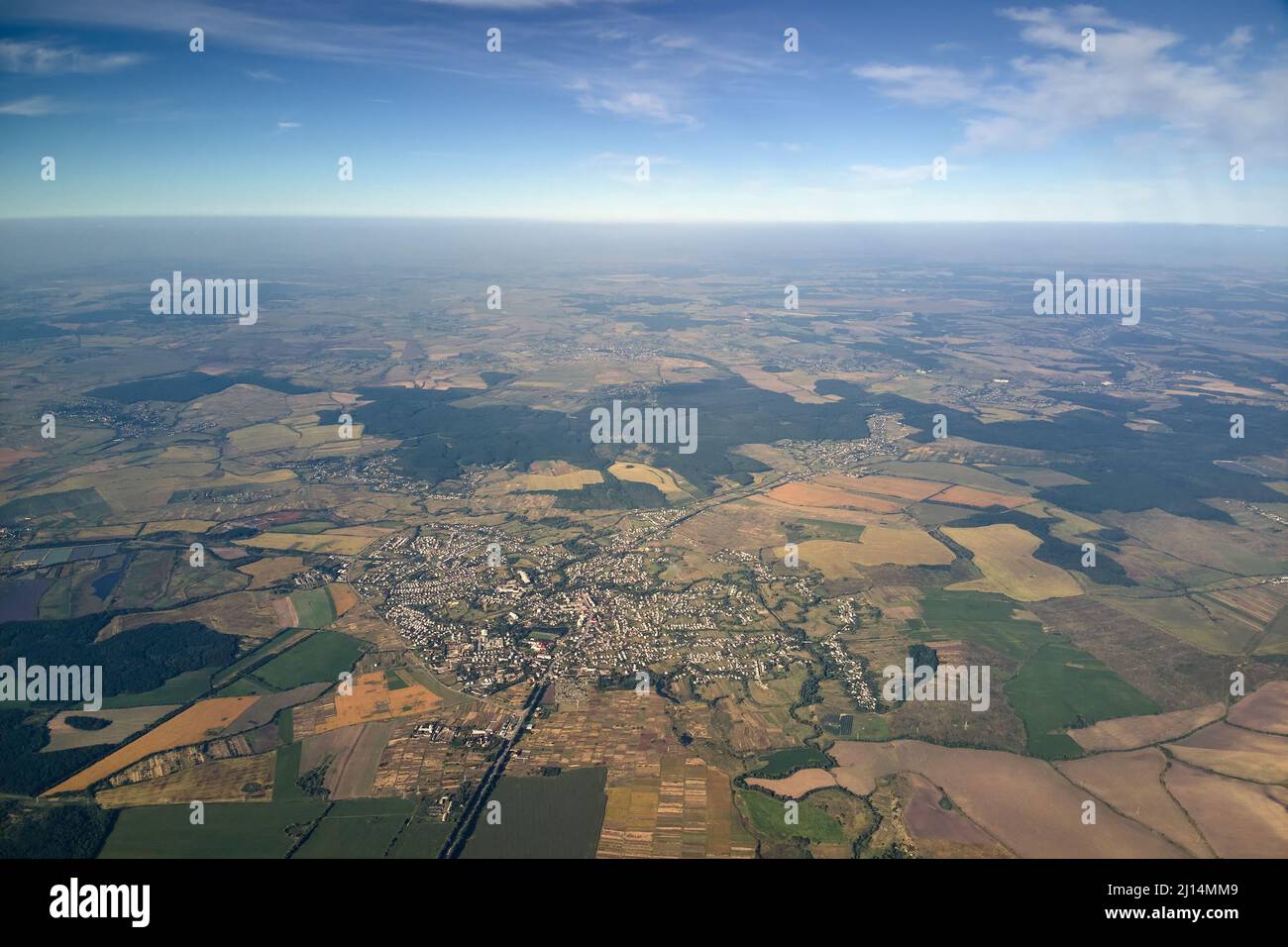 Aerial view of farm fields and distant scattered houses in rural area ...