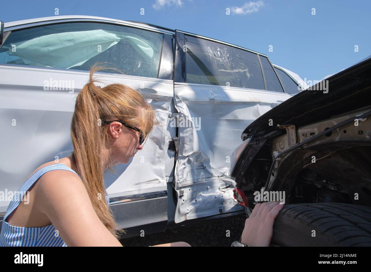 Sad female driver sitting on street side shocked after car accident ...