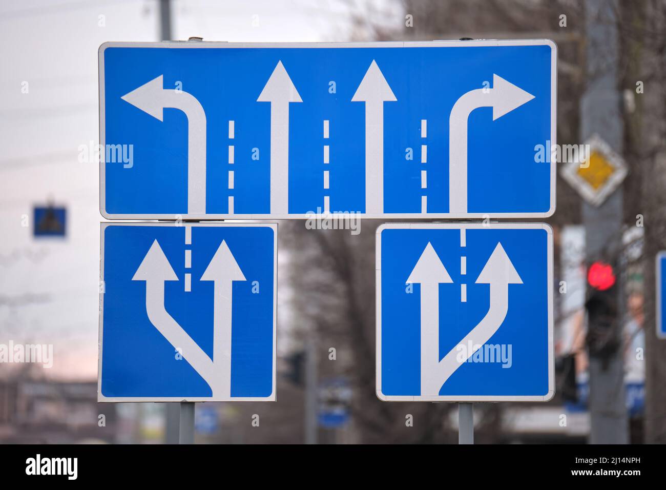 Traffic sign pointing multiple road lanes direction on city street ...