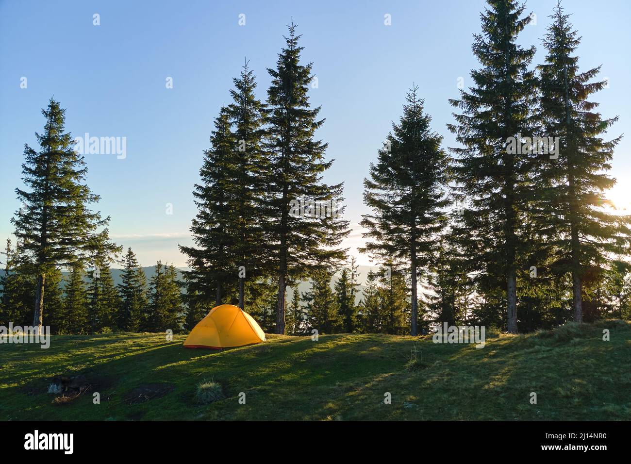 Tourist camping tent on mountain campsite at bright sunny evening ...