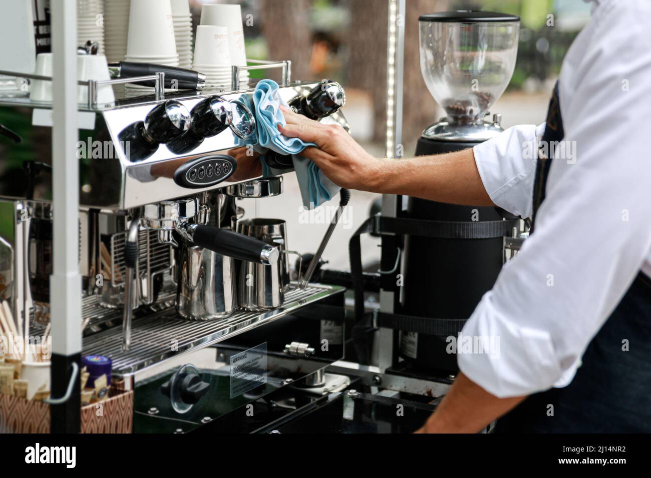 Man cleaning espresso machine after working day Stock Photo - Alamy