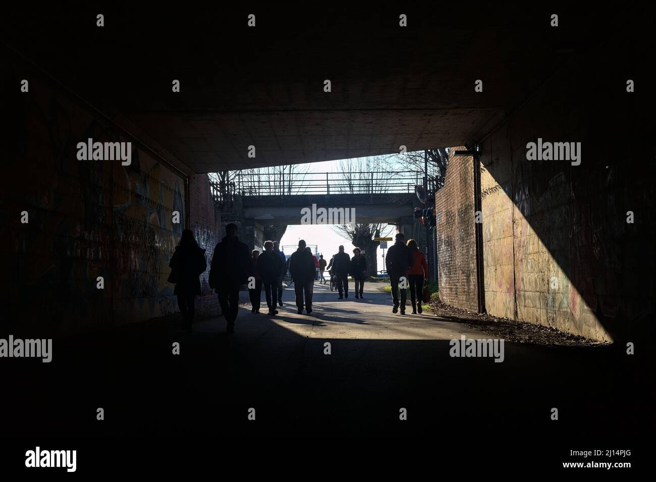 Passageway under a bridge with people strolling on a sunny day Stock ...