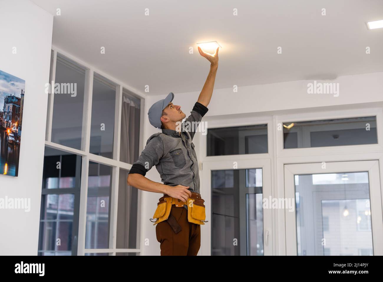 Electrician worker installation electric lamps light inside apartment ...
